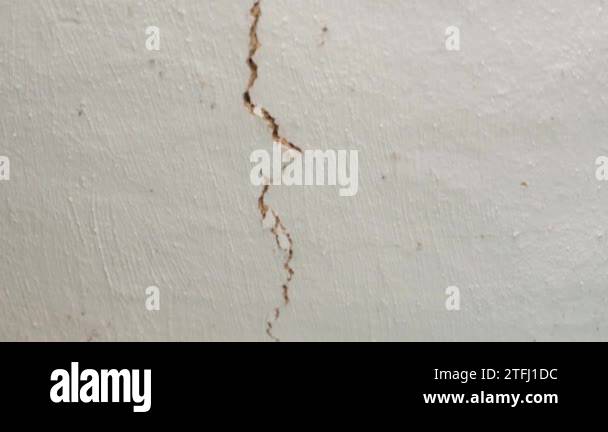 Long crack in the white ceiling of an old rural house close-up. The ...
