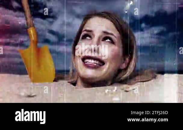 A scared emotional woman buried up to her head on a beach with a spade ...
