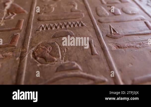 Antique stone wall with carved ancient Egyptian hieroglyphs. Close shot ...
