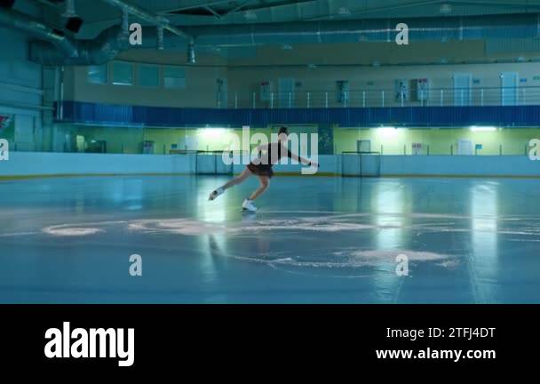 young woman figure skater is engaged in figure skating on ice. she ...