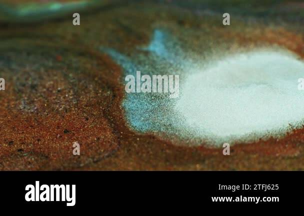 Mixing colors. Fluid magic. Creative painting. White glitter puddle ...