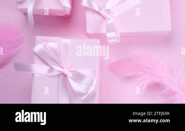 Rotating background with pink gift boxes with pink bows on a pink ...