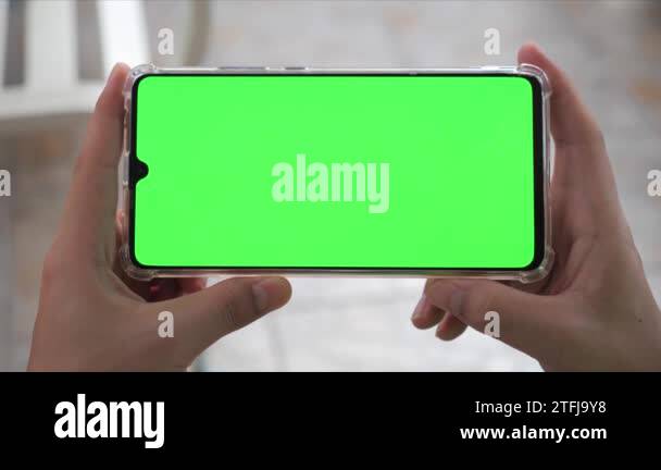Close up Horizontal hands holding smartphone with green screen. Green ...