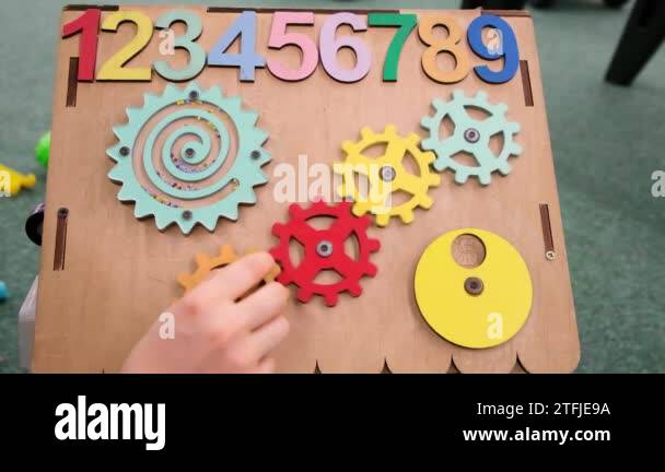 Busy Board for children, wooden board with numbers, gears are spinning ...