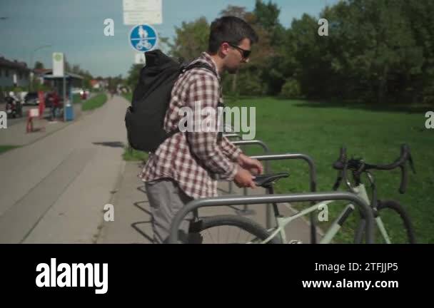 Cyclist parks and locks bicycle in public bike parking lot in Germany ...