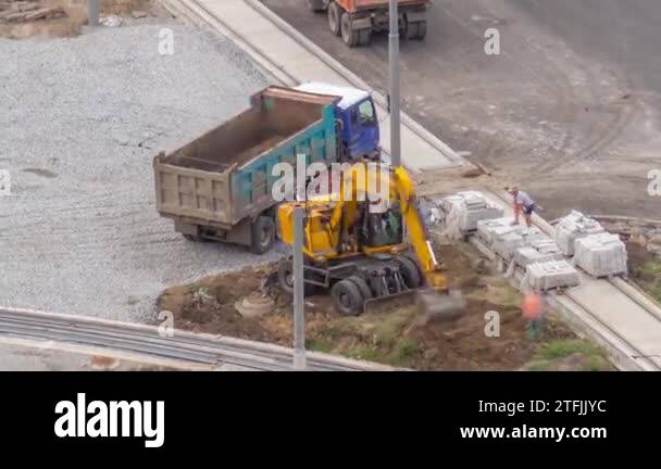 Industrial truck loader excavator moving ground and loading into a dumper truck timelapse on ...