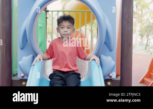 Asian child smiling playing on slider bar toy outdoor playground, happy ...