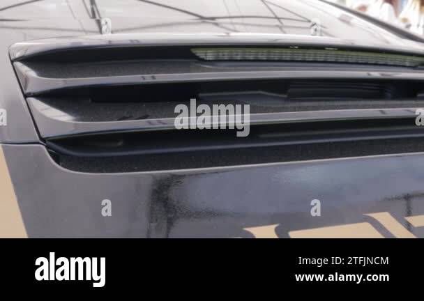 A shiny Porsche 911 sports car with reflective black paint. Details of ...