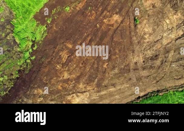 Top view of tractor machine plowing ground on farm field of dust trails ...