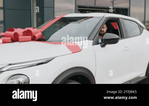 Caucasian bearded man taking white luxury car for test drive from ...