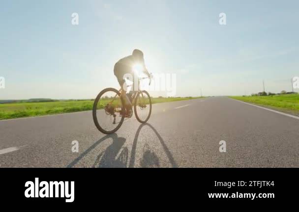 Back view of male cyclist riding sport bike during hard endurance ...