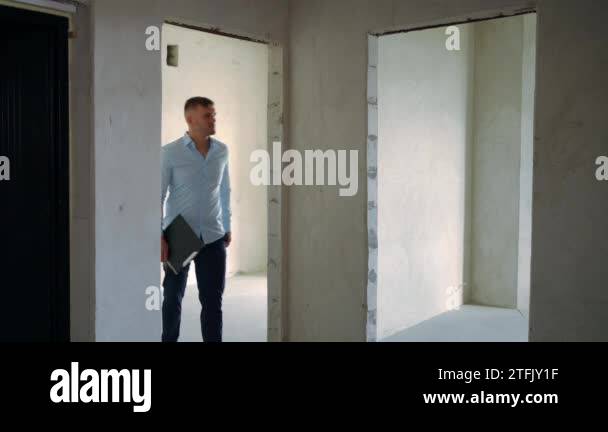 Confident building inspector passing from one room to other leaving ...