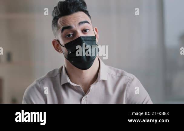 Arabian businessman employee wear medical mask sit at office desk ...