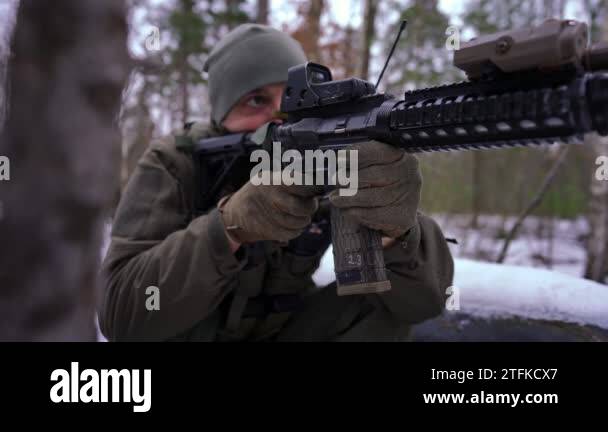 Close-up gun with young man shooting in slow motion outdoors. Armed ...