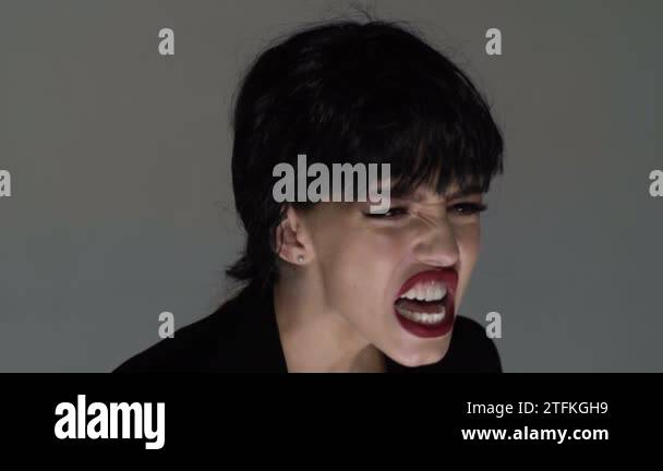 Screaming, hate, rage. Emotional angry woman screaming on gray studio ...