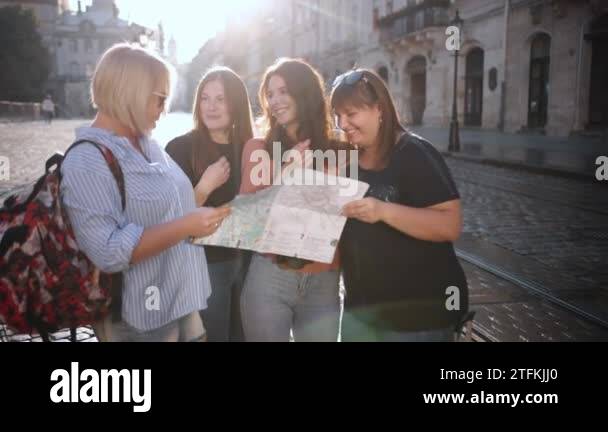 Tourists with maps in the old city during a hot summer day, a female ...