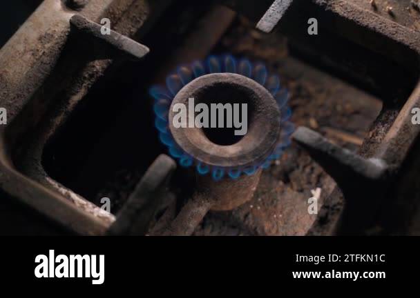 Gas burner of an old kitchen stove with burning gas close-up in motion ...