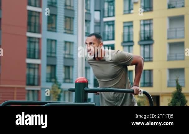 Professional gymnast strong sportsman push ups on parallel bars with ...