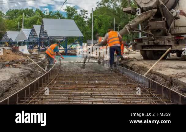 Concrete works in metal reinforcement for road construction with many workers in uniform ...