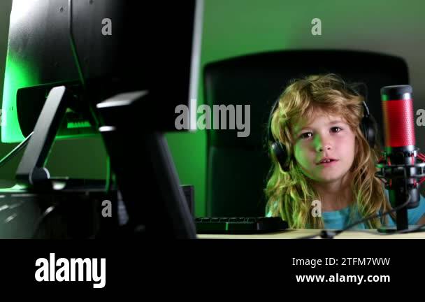 Little child gamer play computer game on desktop. Gaming stream and ...