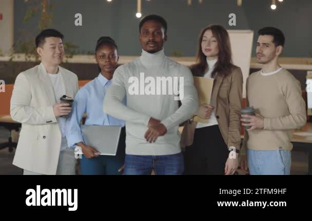 Multiracial company staff standing and crossing hands in office. Group ...