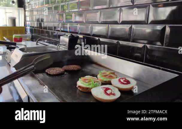 8K 7680x4320.Burgers are cooking in the burger shop.Chef working fatty patties.Hamburger shop by ...