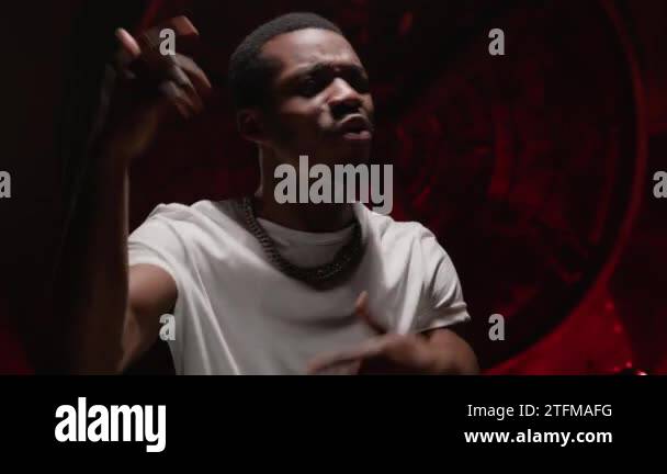 Black man teenage hip hop artist raps and waves his arms while ...