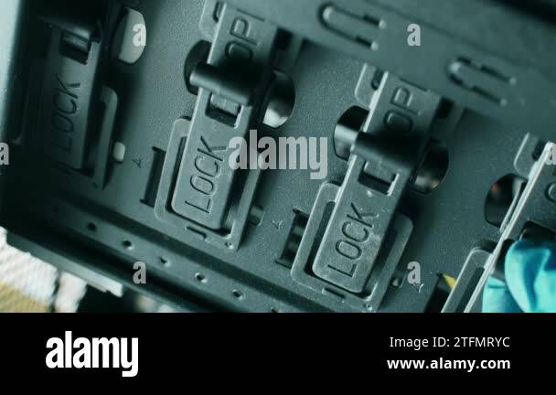 A blue gloved hand closes the switches from the Open to the Lock ...