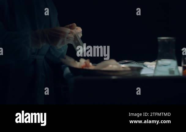 Nurse hands preparing tools for wound suturing in dark operating room ...
