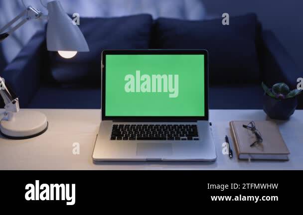 Modern laptop with mock up chroma key green screen on table of living ...