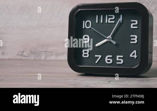 The pointer clock on wooden table shows time 8 oclock. Arrow brown ...