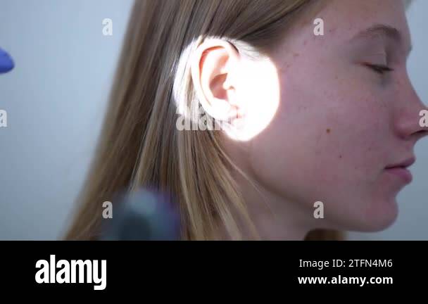 Close-up side view ear of female teenage patient with rack focus to ...