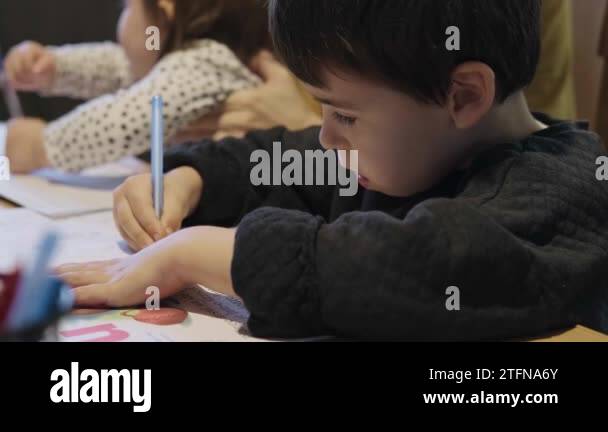 Its time for homework. The primary school boy does his homework with ...