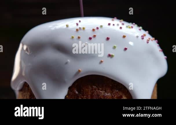 Rotating Easter cake, decoration with white glaze and colorful sugar ...