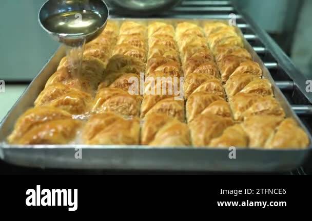 Pouring syrup on baklava. Pouring sweet syrup on Turkish Baklava with ...