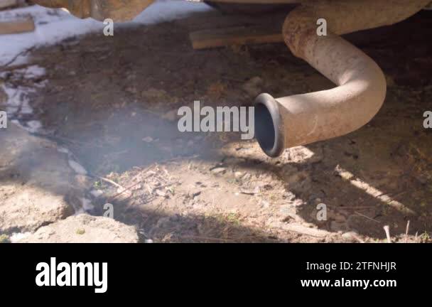 From the rusty exhaust pipe of an old diesel car, smoke comes out when ...