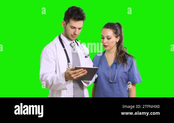 Two young doctors looking at a digital tablet isolated on green screen ...