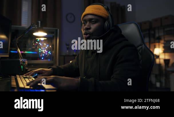 Mens room at night lit by led lights. A pro gamer sits in front of a ...