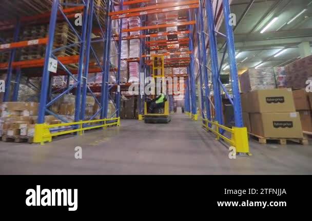 A modern forklift rides through a warehouse. Large modern warehouse ...