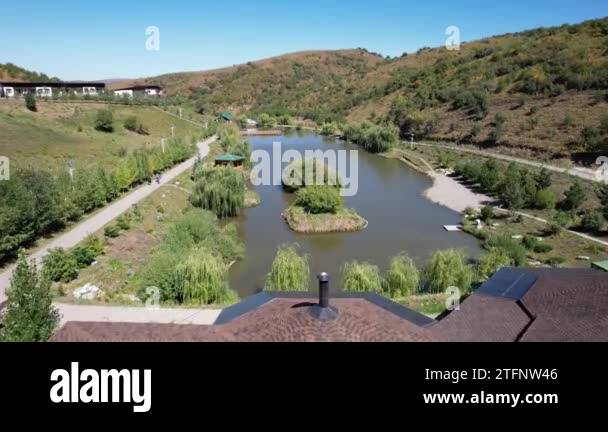 Drone view of a ranch with hotels in the mountains. Beautiful big pond ...