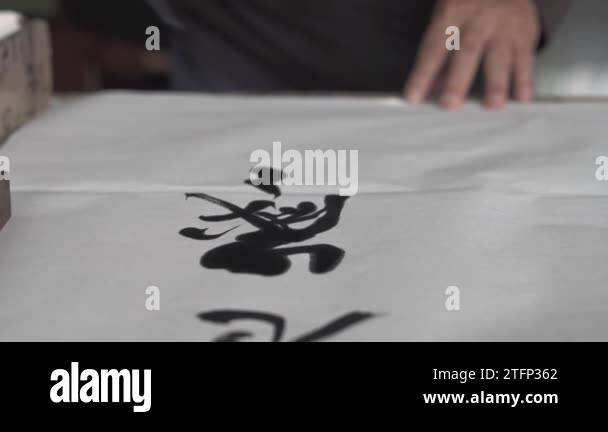 An old calligrapher is creating and writing Chinese calligraphy works ...