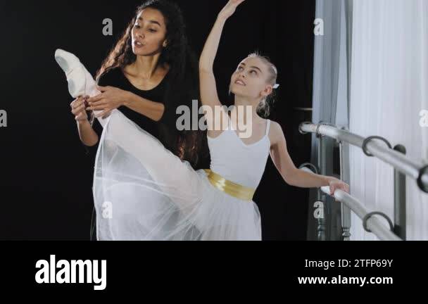 Concentrated teen girl learning ballet dance in studio with female ...
