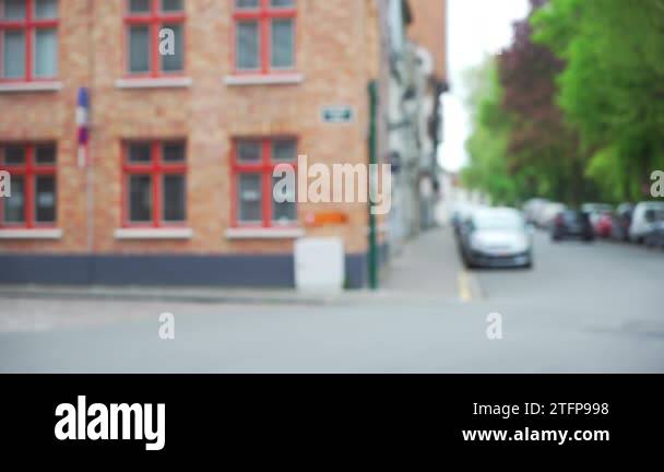 Out of focus background plate of busy city street corner with trees on ...