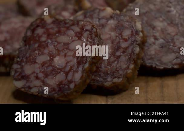 Pieces of salami on a wooden surface, close-up video. Delicious ...