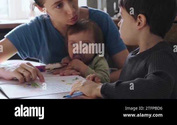 Little boy doing his math homework with a little help of his mother ...