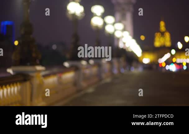Blurred view of Pont Alexandre III at night with lights and Les ...