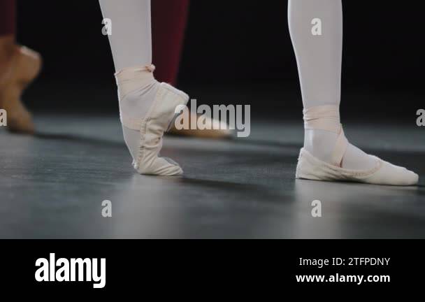 Two pairs of female legs on floor on performance stage in dance class ...