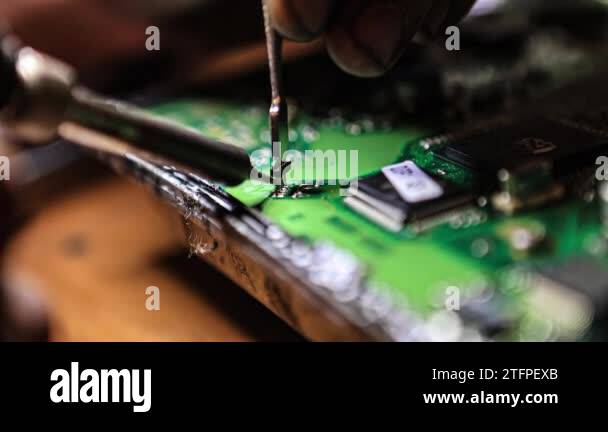 Car ecu soldering. Car Ecu Detail with visible components with hand ...