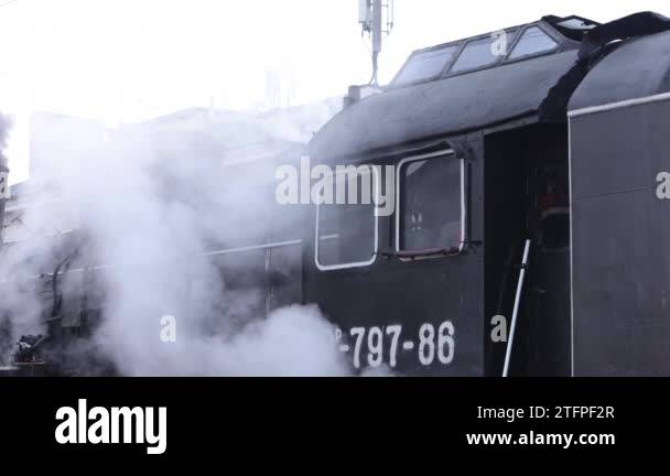 Steam locomotive train approaching station passing through goods yard ...