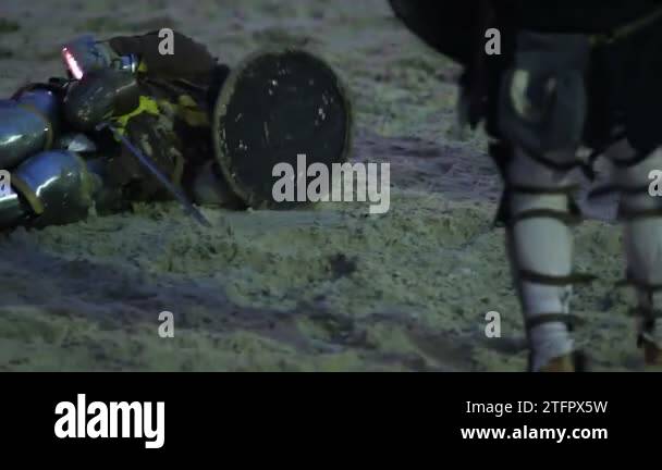 Wounded knight lying on battlefield and writhing in pain. Medieval ...